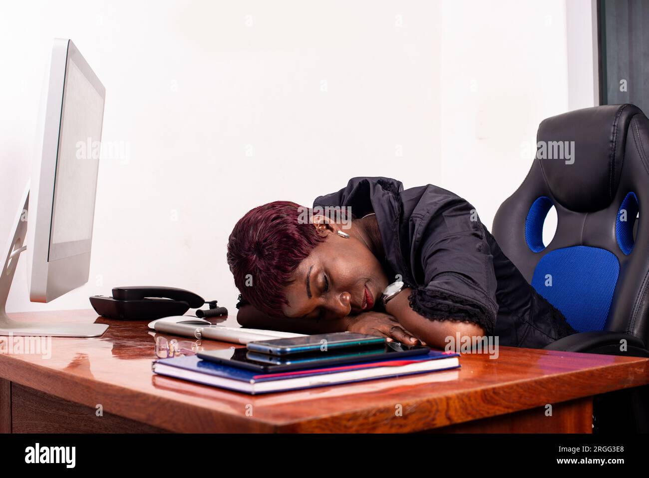 a beautiful businesswoman sitting at the desk tired falling asleep in ...