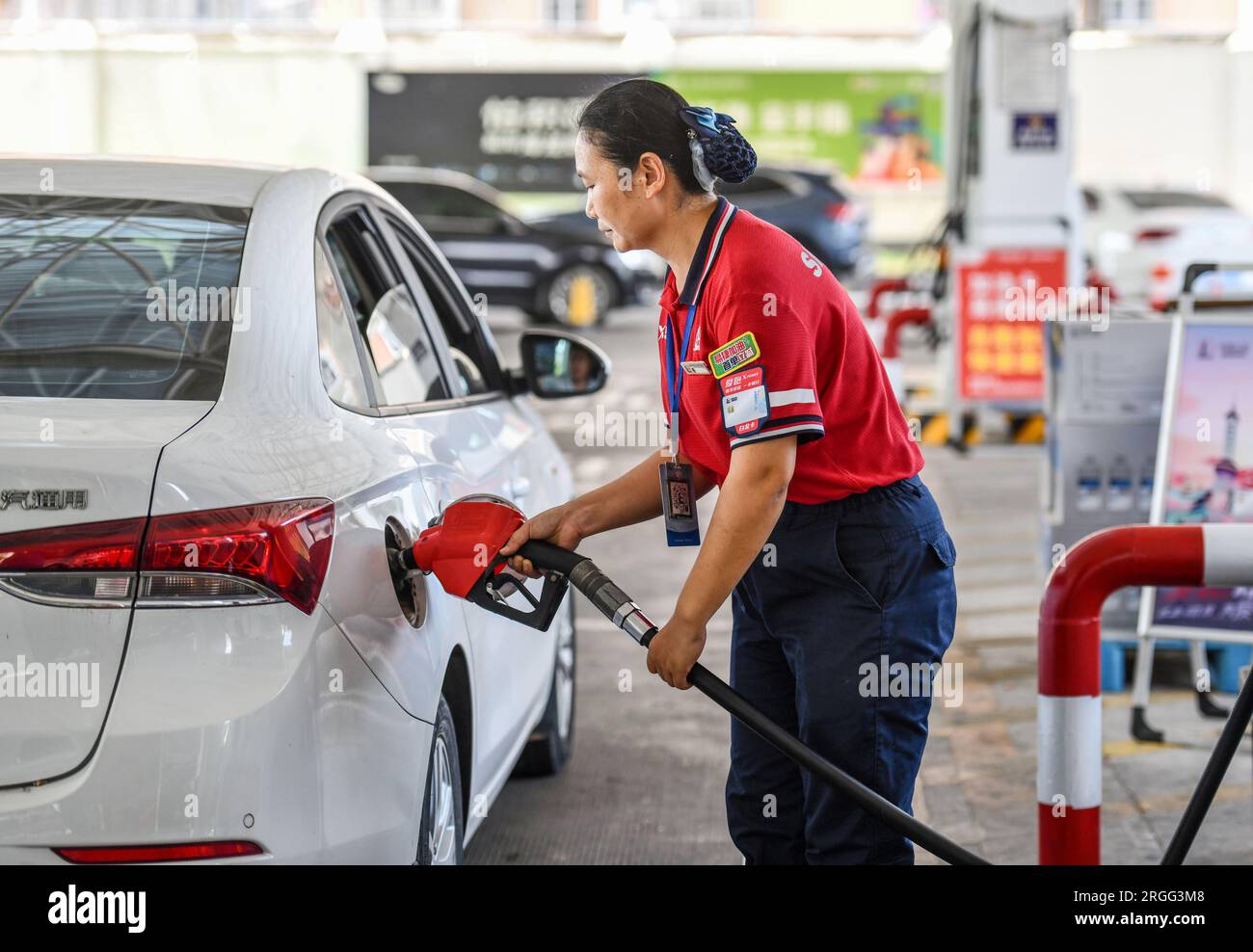 Fuyang, China. 09th Aug, 2023. A female worker at a gas station pumps ...