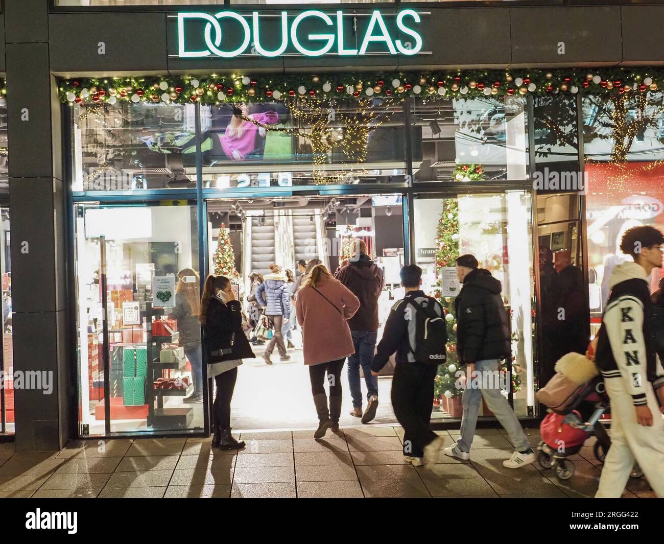 People in front of a Douglas store at night. Douglas Holding AG ...