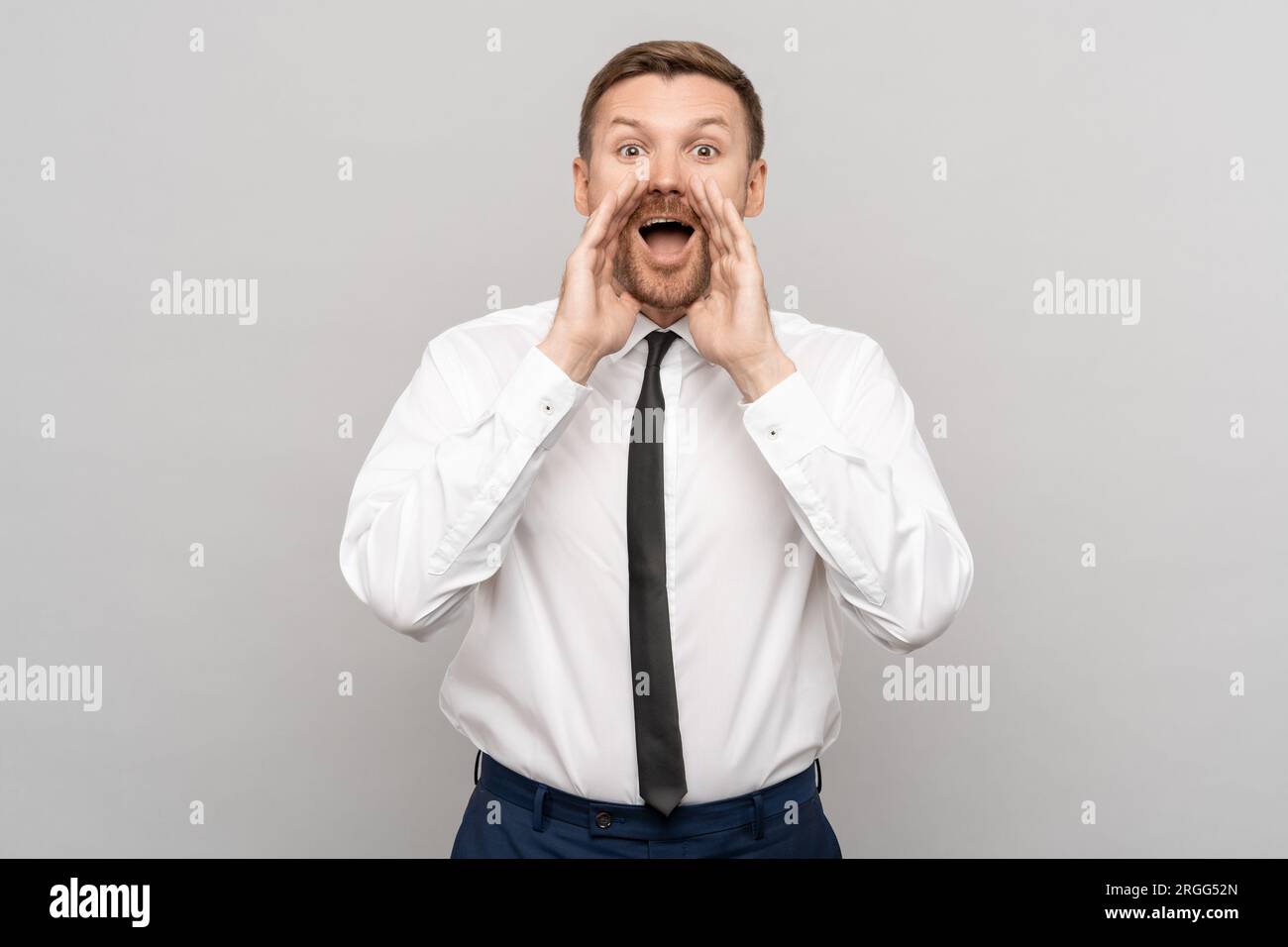 Businessman makes loud sound noise with hands at mouth sides for ...