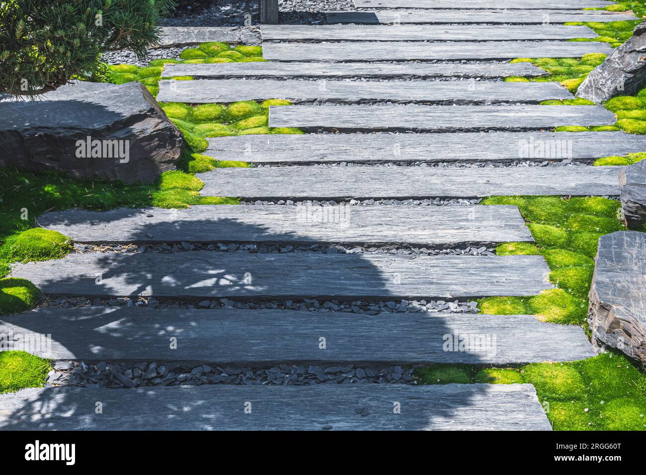 Path with wide stone slabs leads through a Japanese garden Stock Photo ...