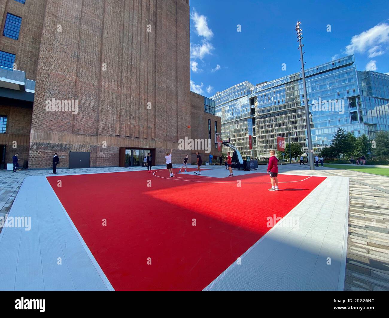 boys playing basketball on red court at battersea power station south ...