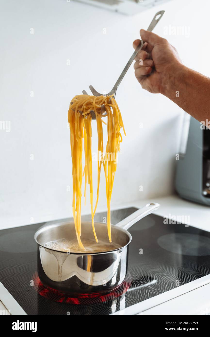 Pasta cooking hand pot water home hi-res stock photography and images ...