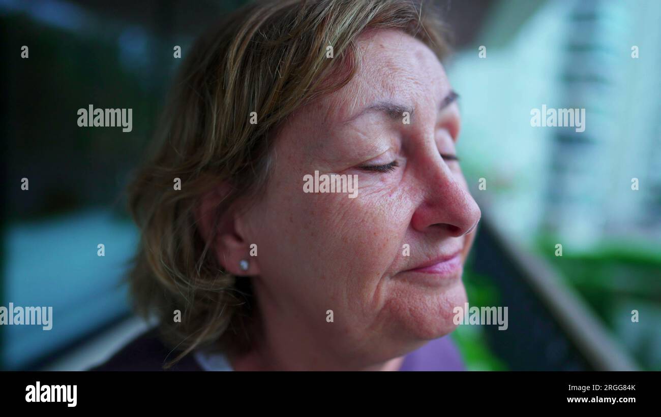 One senior woman closing eyes in contemplation. A meditative older lady ...