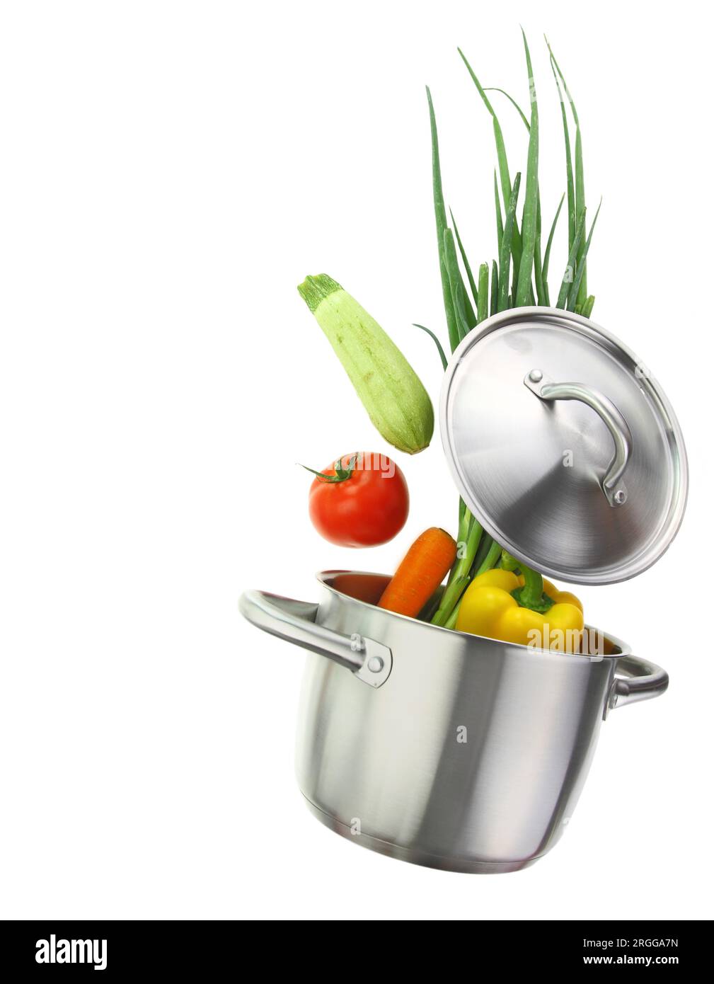 Fresh vegetables falling into a cooking pot isolated on white ...