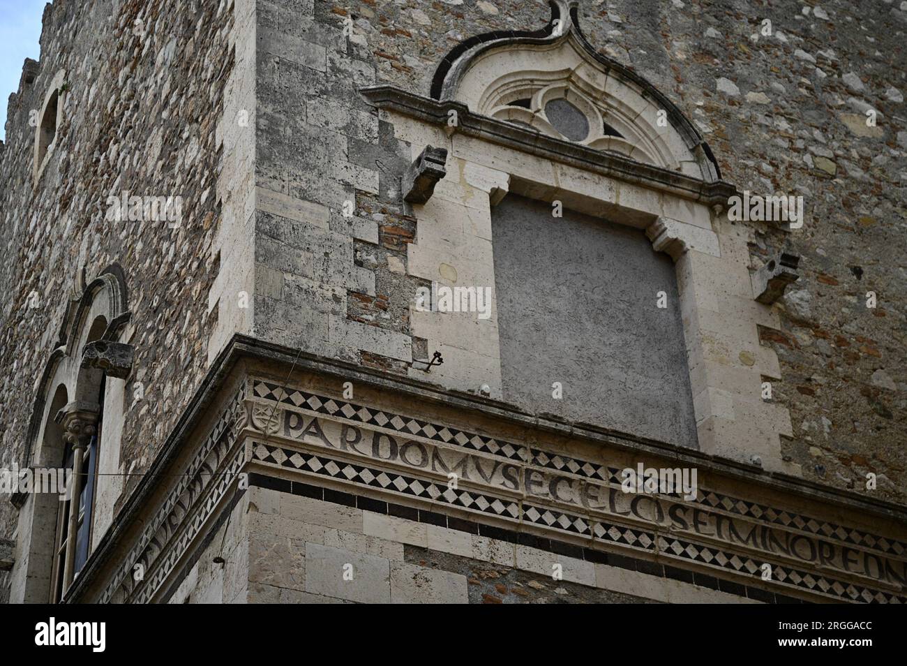 Medieval stone wall with Gothic style ogival windows and ancient Roman ...