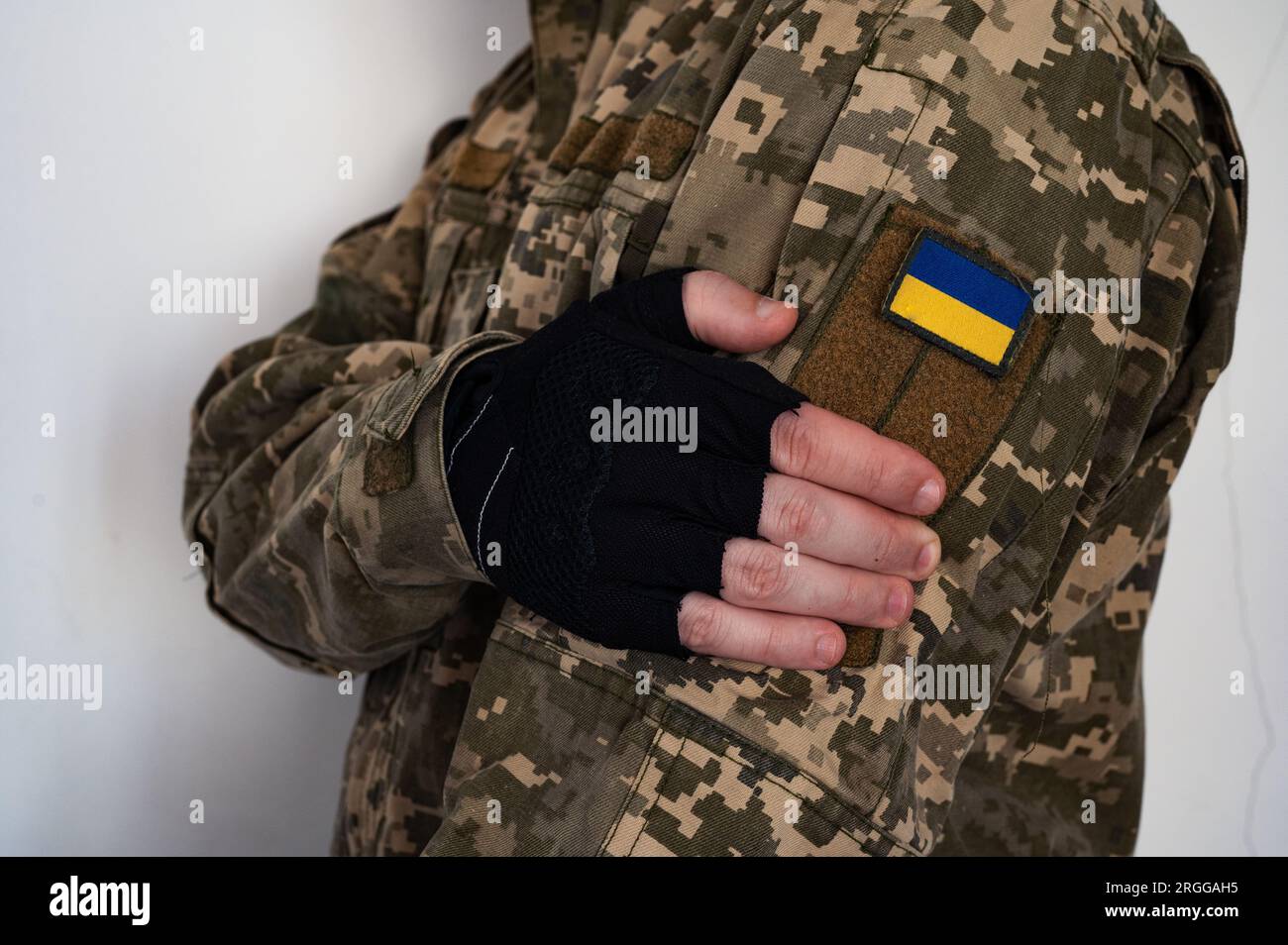 Ukrainian soldier in military pixel unform with banner of flag of ...