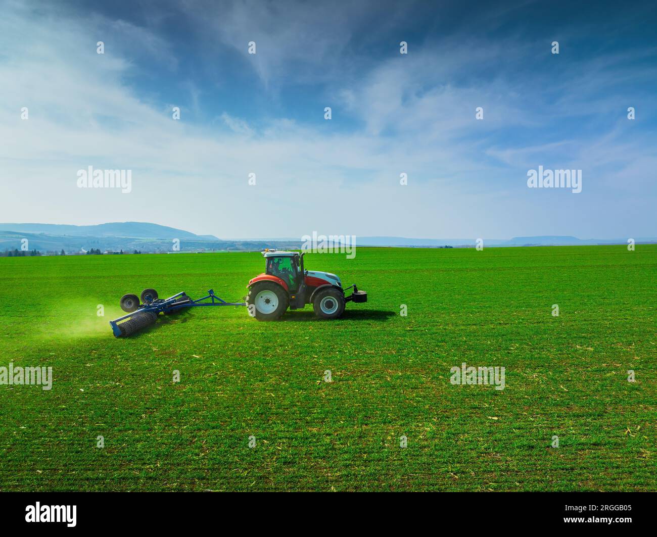 Tractor with a roller tillage on spring field. Aerial view of Soil ...