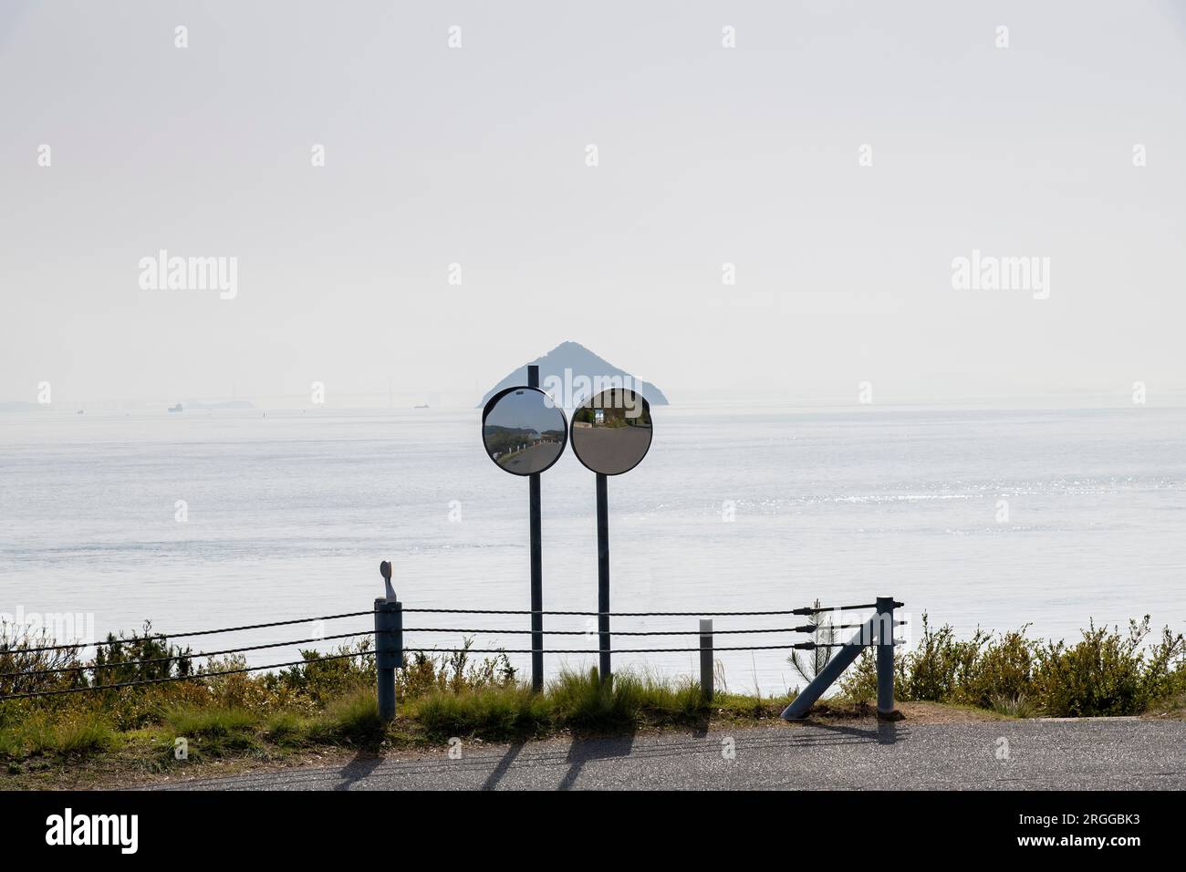 Two convex traffic mirrors in corner of road with in background a ...