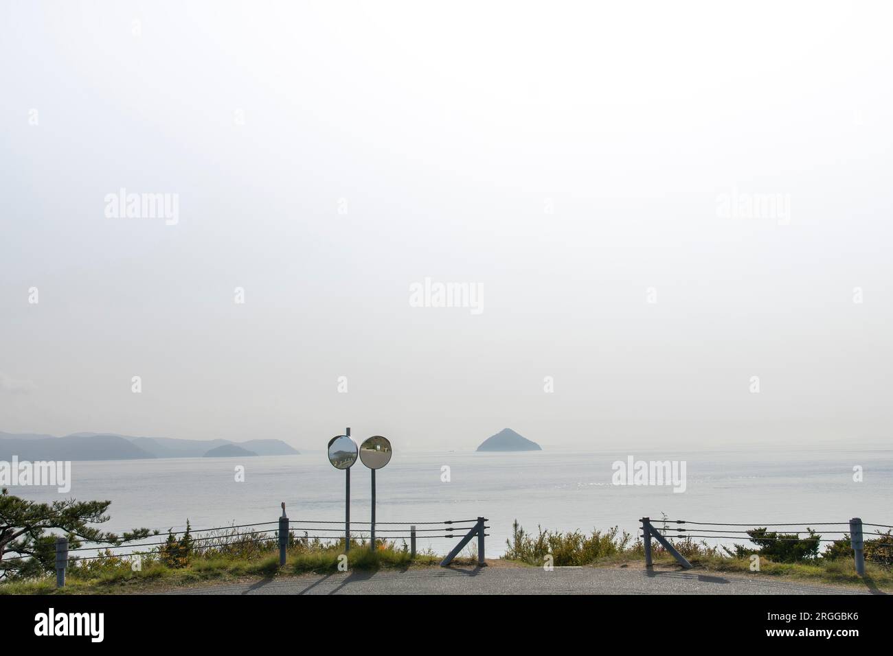 Two convex traffic mirrors in corner of road with in background a ...