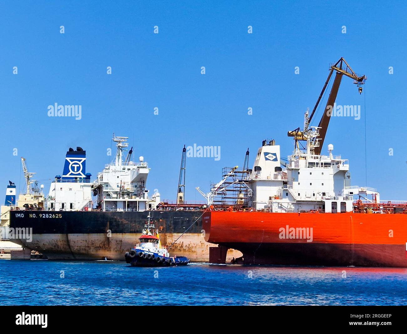 Tugs towing a ship to Onex Neorion Shipyard, Syros island, Greece ...