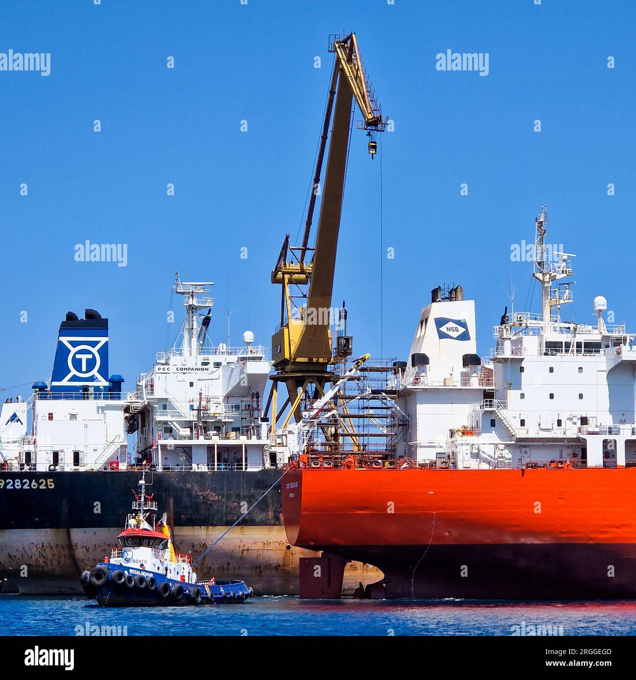 Tugs towing a ship to Onex Neorion Shipyard, Syros island, Greece ...