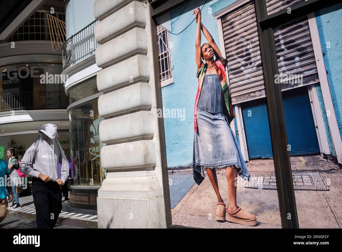 A retail hoarding stands overhead shoppers walking down Regent Street ...
