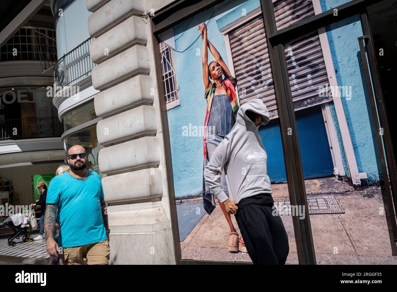 A retail hoarding stands overhead shoppers walking down Regent Street ...