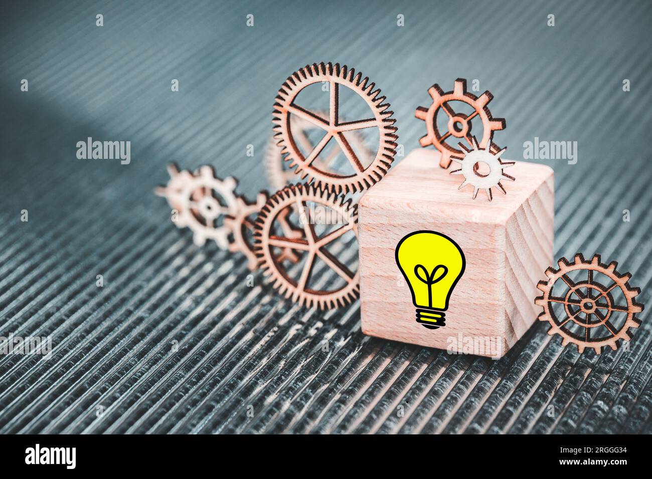 Light bulb symbol on a wooden block, clockwork gears and mechanism ...