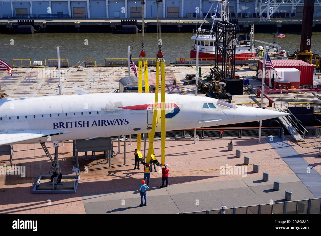 A crew prepares to lift the British Airways Concorde off the Intrepid ...