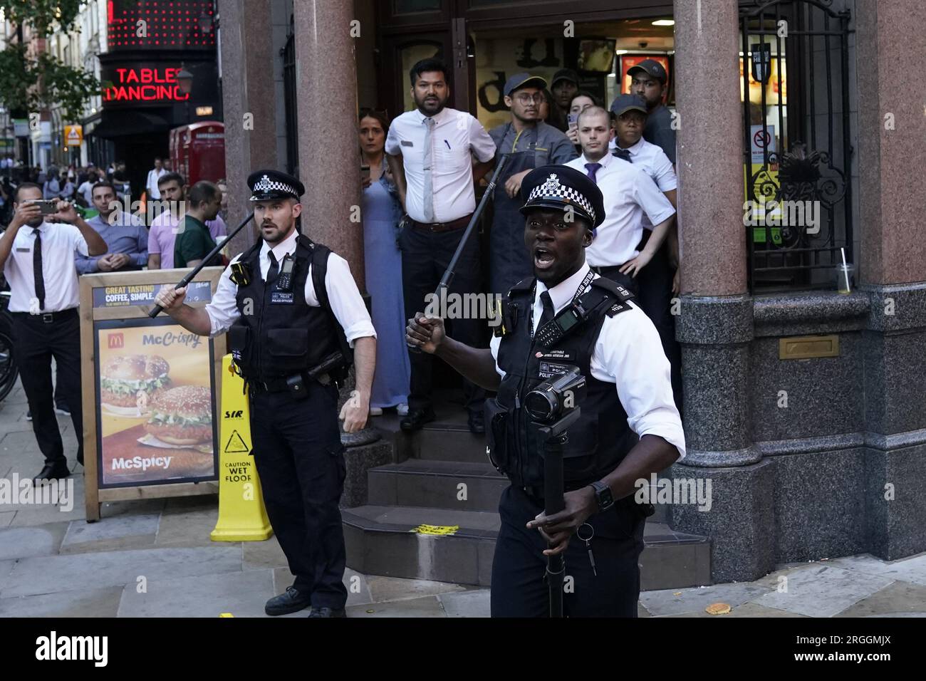 Police officers with batons outside a McDonalds store on Oxford Street ...