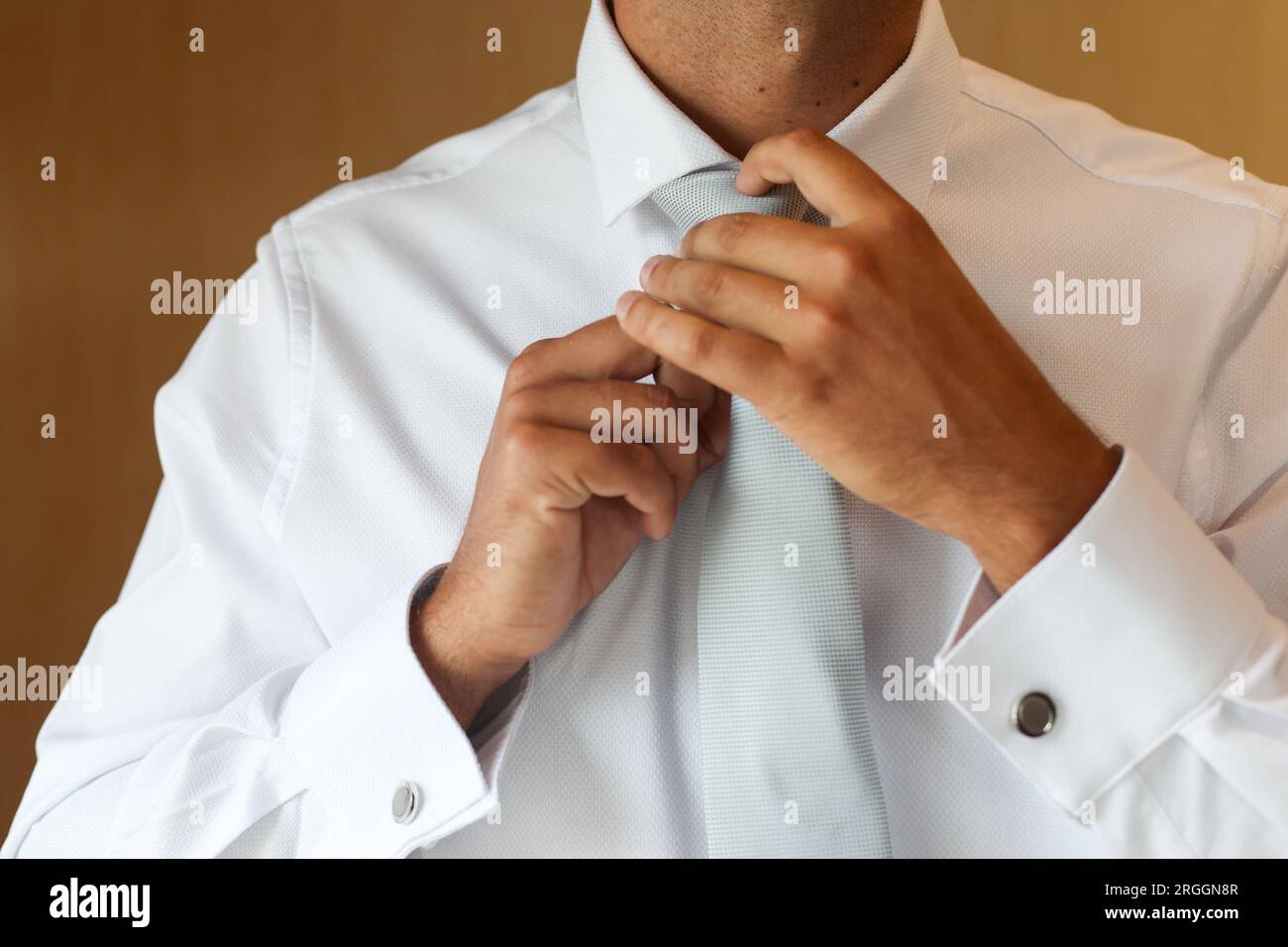 man tightening his tie on his wedding day Stock Photo - Alamy