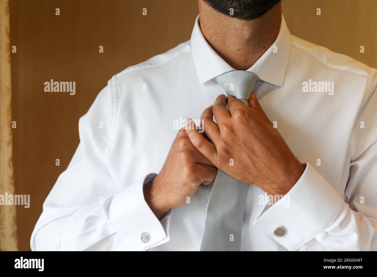 man tightening his tie on his wedding day Stock Photo - Alamy