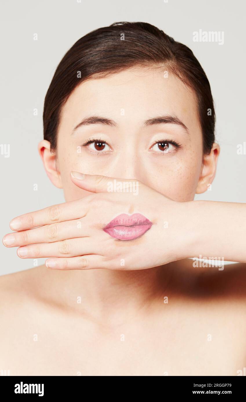 Young woman with lips drawn on her hand Stock Photo - Alamy