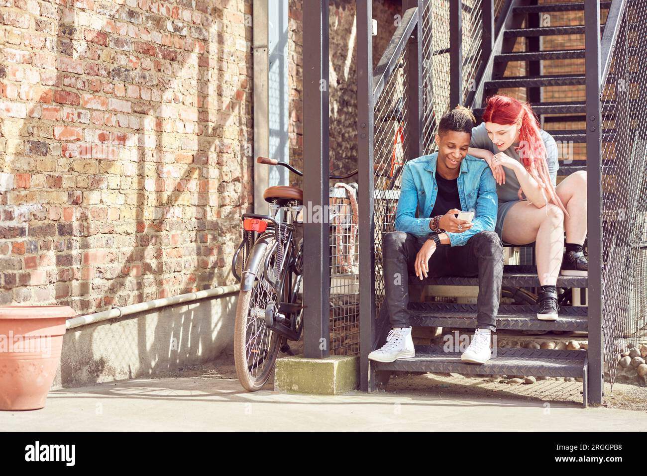 Teenage couple sitting on steps together Stock Photo - Alamy
