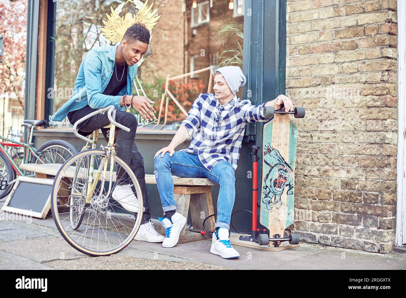 Teenage boy on bicycle talking to his friend Stock Photo - Alamy