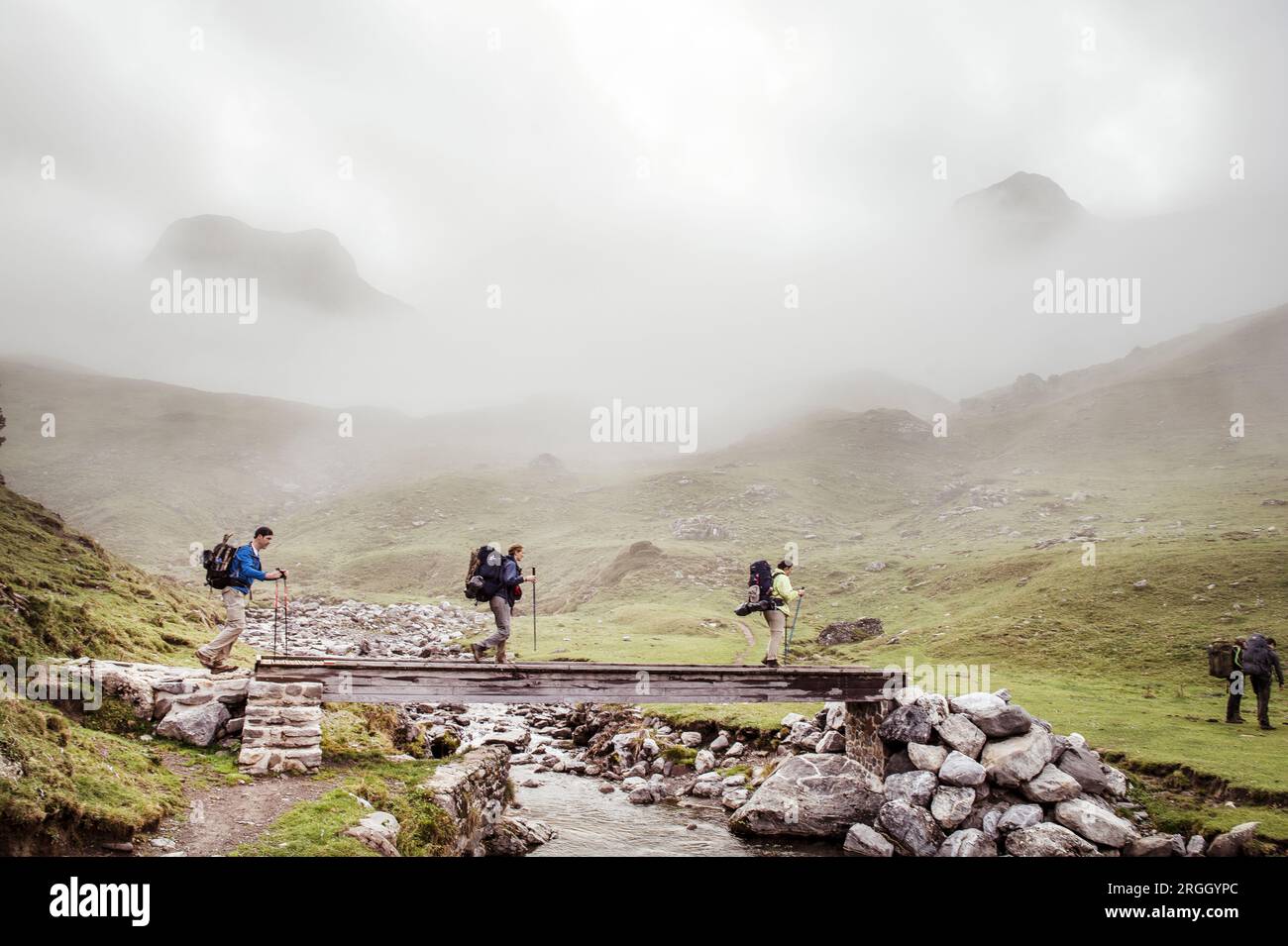 Group of hikers crossing bridge over river Stock Photo - Alamy