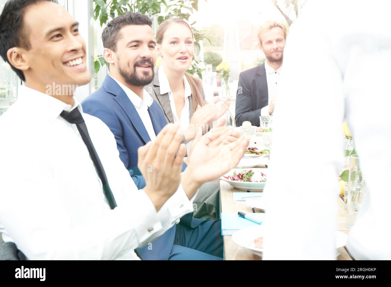 Businesspeople smiling and clapping in restaurant Stock Photo - Alamy