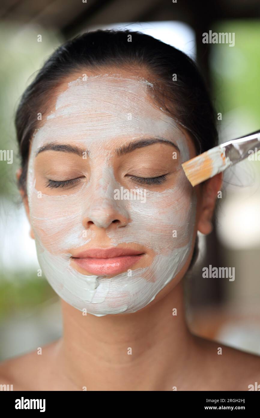 Young woman having face mask applied with brush Stock Photo - Alamy