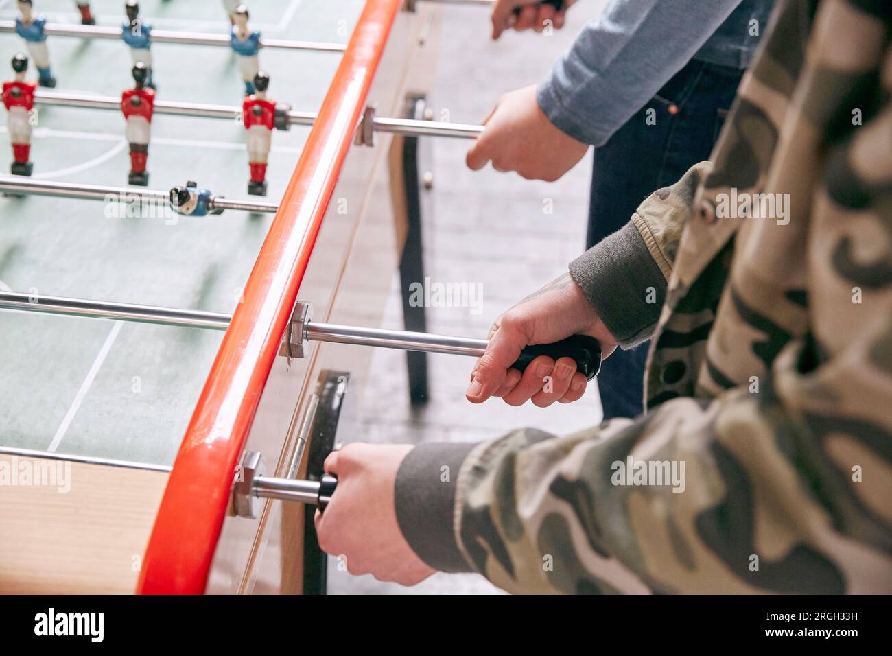 Hands of teenage boys playing table football Stock Photo - Alamy