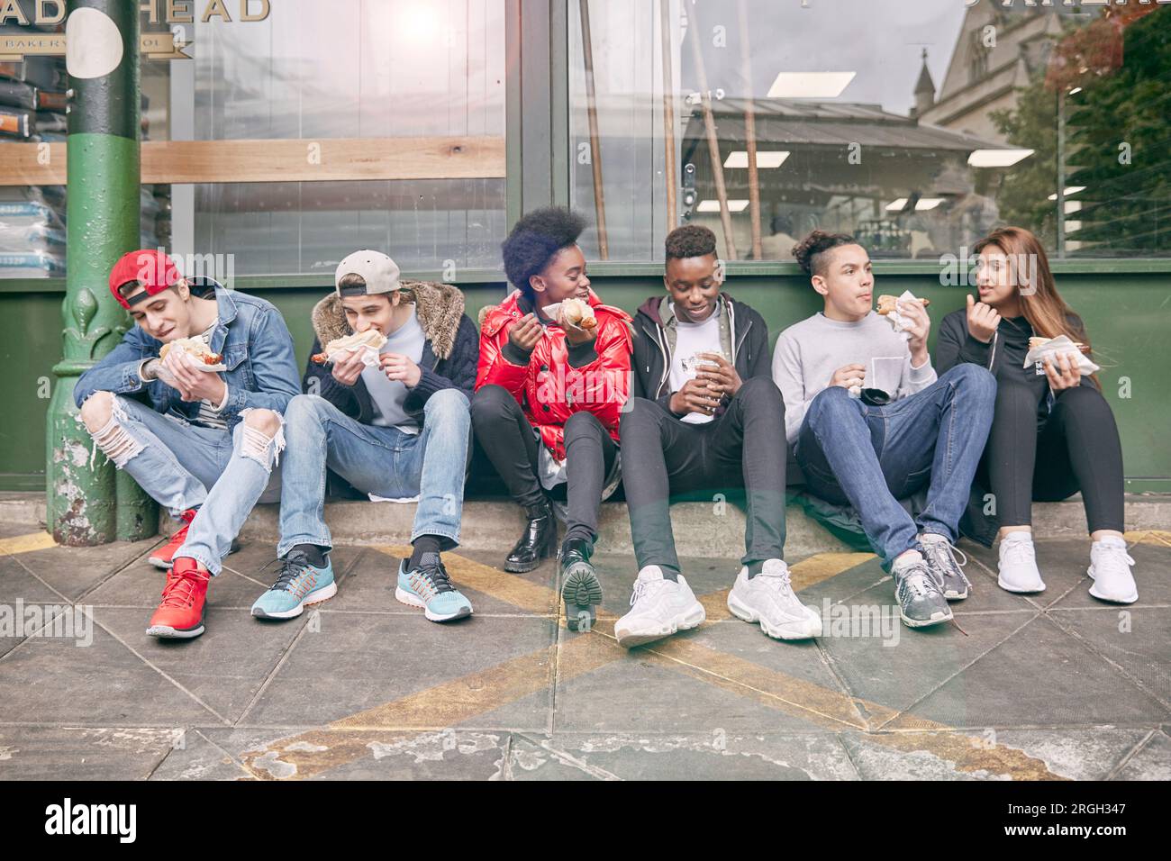 Teenage friends eating fast food Stock Photo - Alamy