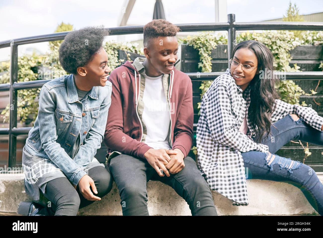 Teenage friends sitting together Stock Photo - Alamy
