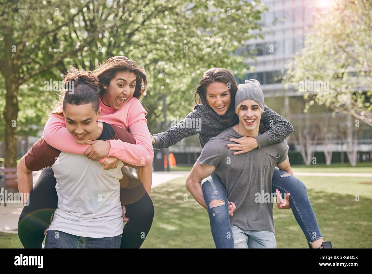 Teenage couples having piggyback race Stock Photo - Alamy