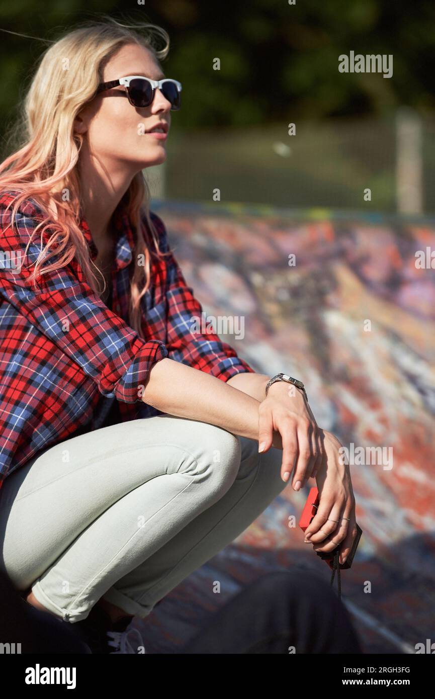 Crouching teenage girl holding camera Stock Photo - Alamy