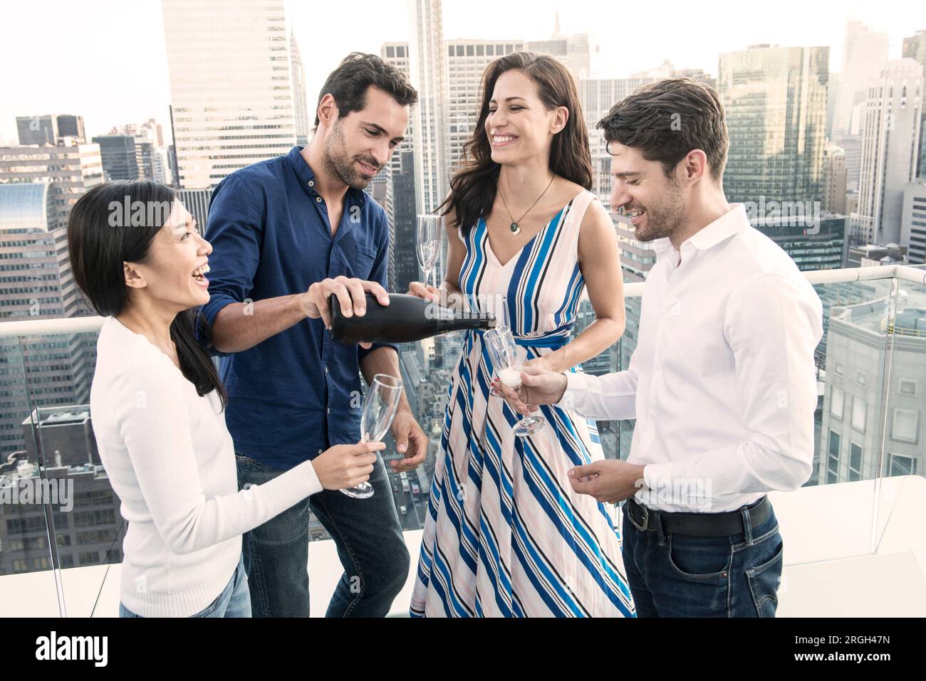 Friends on balcony with champagne in New York City Stock Photo - Alamy