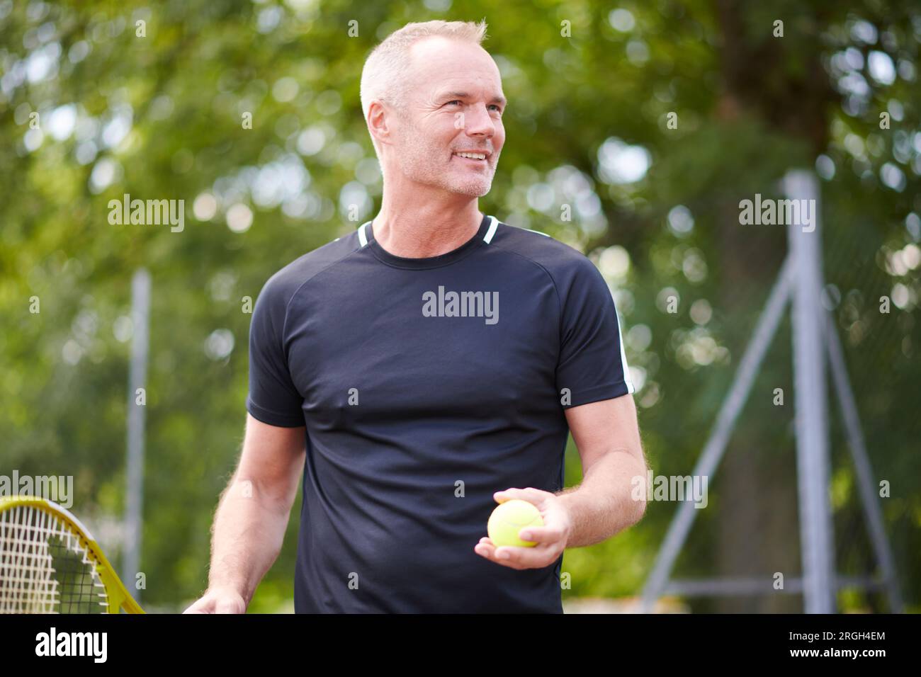 Mature man holding tennis racket and ball Stock Photo - Alamy