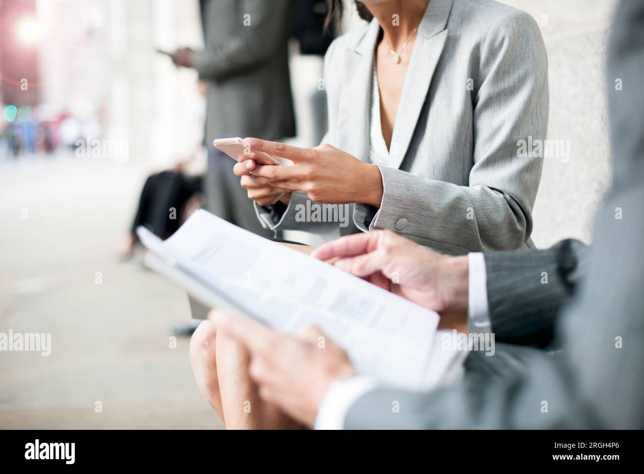 Businesspeople holding newspaper and smart phone Stock Photo - Alamy