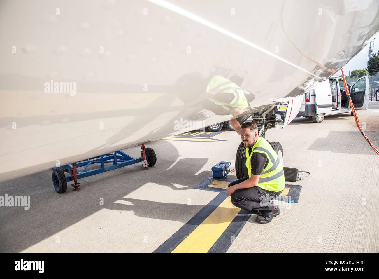 Worker fixing airplane wheel Stock Photo - Alamy