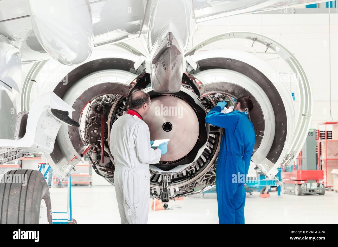 Men working on airplane engine in hangar Stock Photo - Alamy