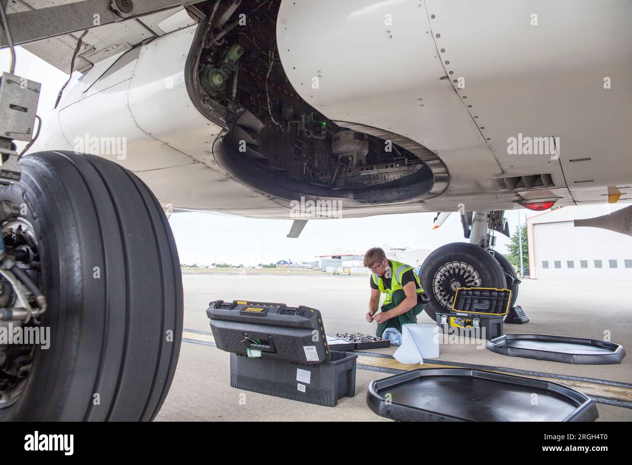 Worker fixing airplane wheel Stock Photo - Alamy