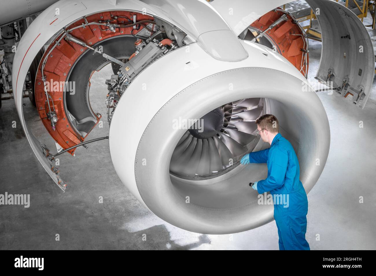 Man working on airplane engine in hangar Stock Photo - Alamy