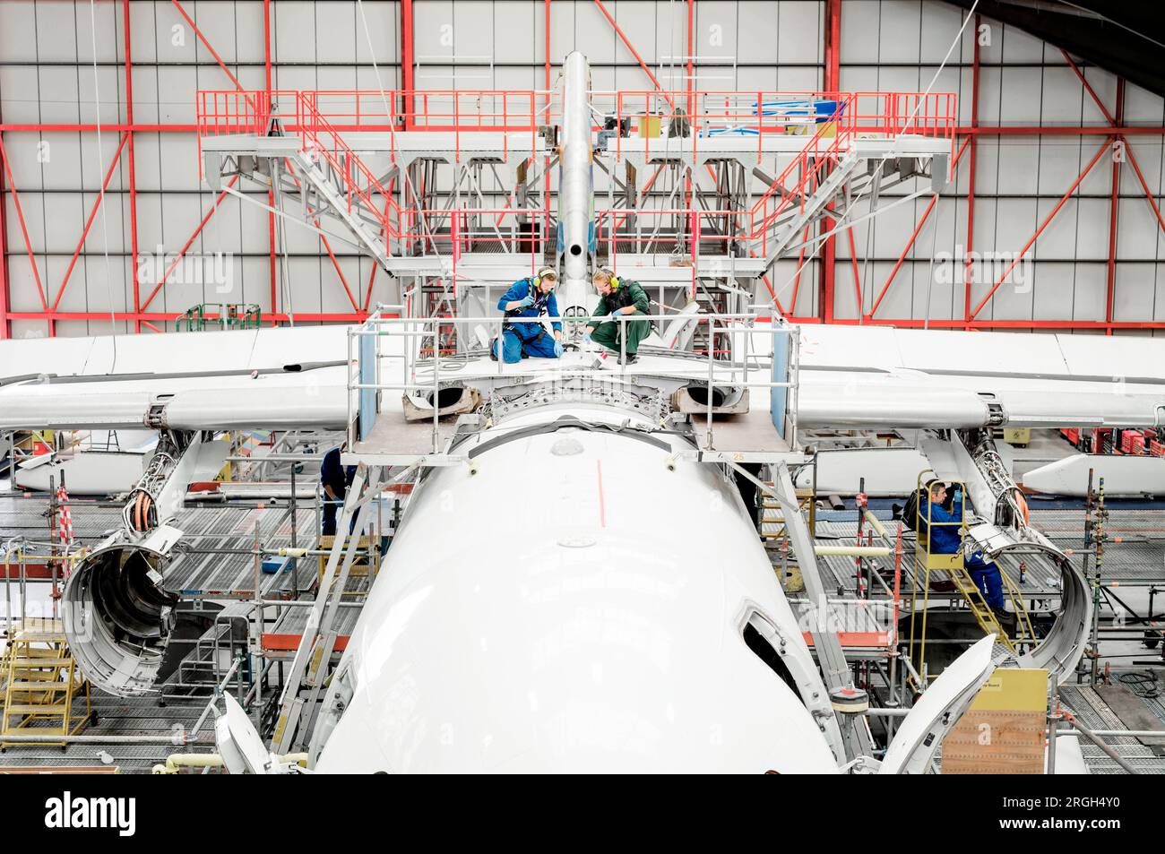 Workers on airplane in hangar Stock Photo - Alamy