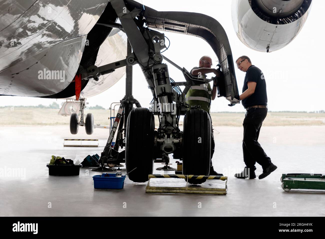 Men working on airplane wheel Stock Photo - Alamy
