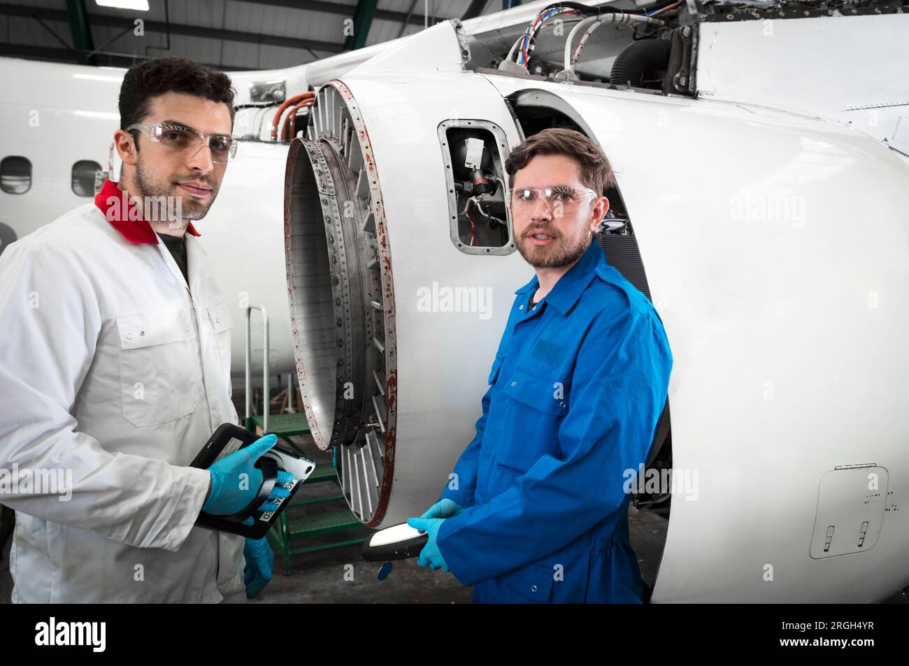 Men holding digital tablet and electric torch by airplane engine Stock ...