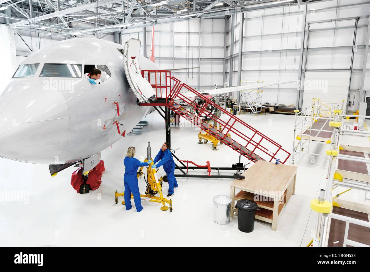 Workers in airplane hangar Stock Photo - Alamy