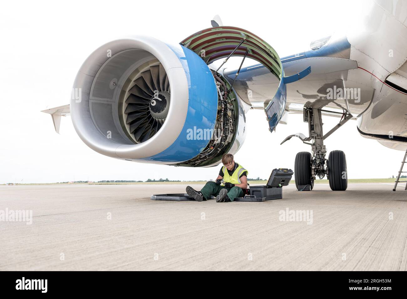 Man working on airplane engine on runway Stock Photo - Alamy