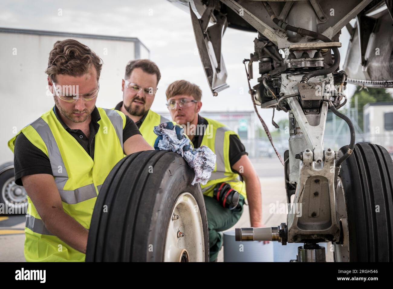 Men working on airplane wheel Stock Photo - Alamy