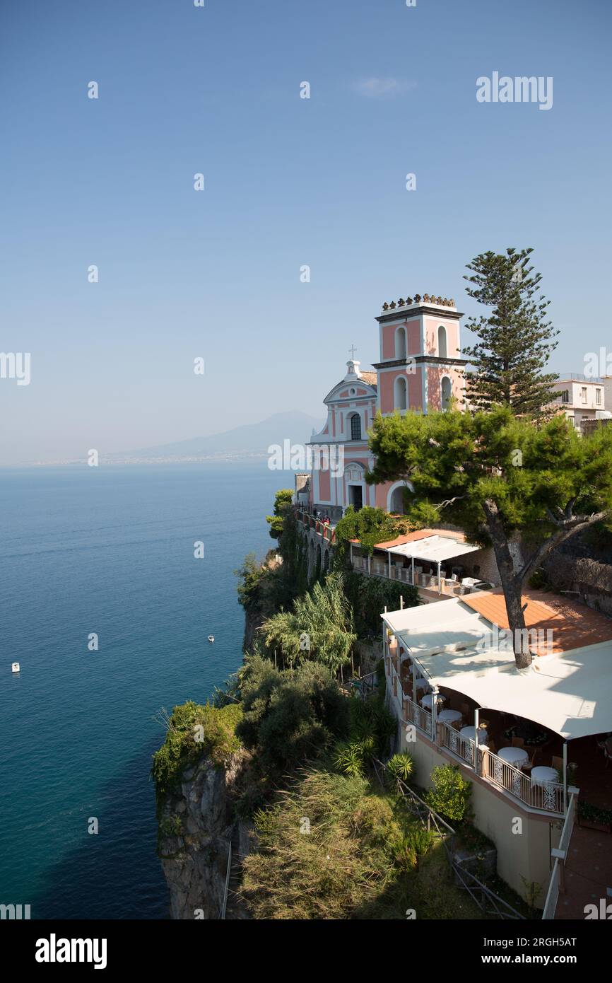 Pink building on cliff over sea Stock Photo - Alamy
