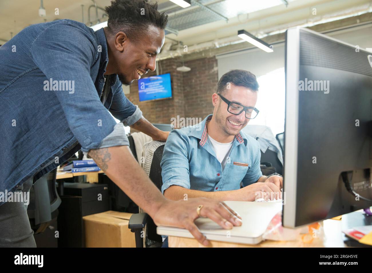 Smiling colleagues using computer Stock Photo - Alamy