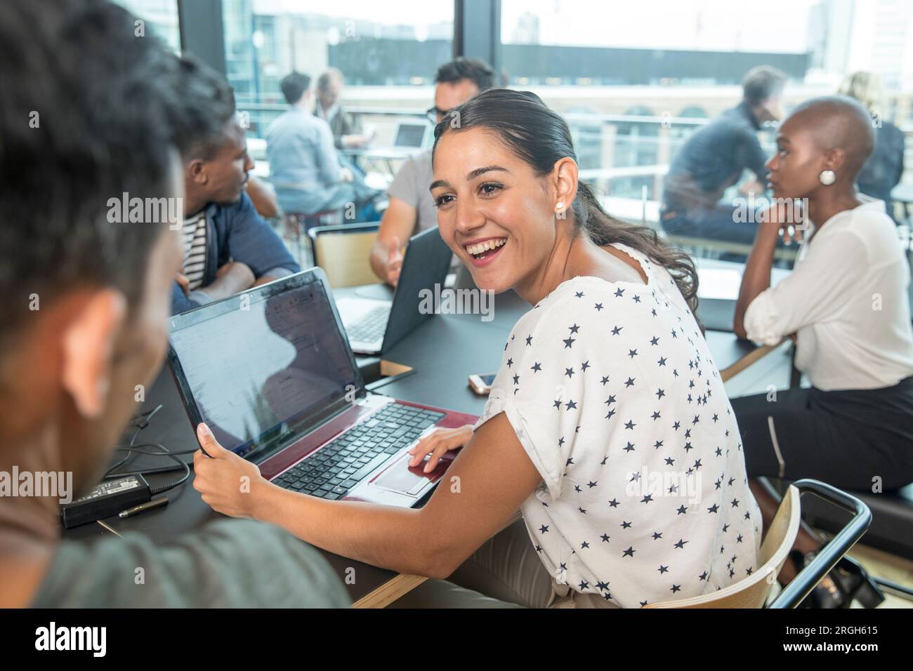 Colleagues using laptops during meeting Stock Photo - Alamy